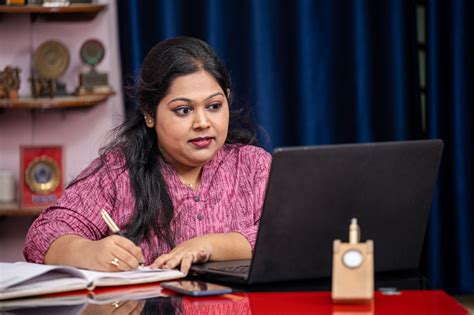 테이블에 앉아 홈 오피스에서 일하는 노트북 컴퓨터에 입력 하는 인도 젊은 성인 여자 미소 20 24세에 대한 스톡 사진 및 기타 이미지 20 24세 25 29세 가정