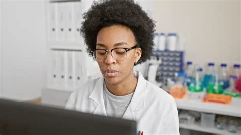 A Focused African American Woman Scientist Analyzing Data On A Computer In A Laboratory Setting