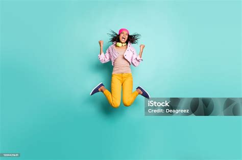 전체 길이 바디 사이즈 사이드 프로필 사진 캐주얼 긍정적 인 점프 실행 여학생 노란 바지 핑크 재킷 티셔츠 고립 선명한 색상