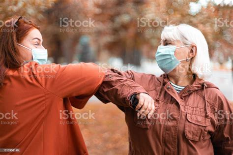 두 사람이 야외에서 코로나 바이러스를 피하기 위해 팔꿈치를 범프 사회적 거리 유지 모임에 대한 스톡 사진 및 기타 이미지 모임 보호 마스크 야외 Istock