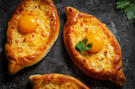 치즈로 속을 채우고 달걀 노른자를 얹은 Ajarian Khachapuri 어두운 배경에 전통적인 조지아 Khachapuri 노랑에 대한 스톡 사진 및 기타 이미지 Istock
