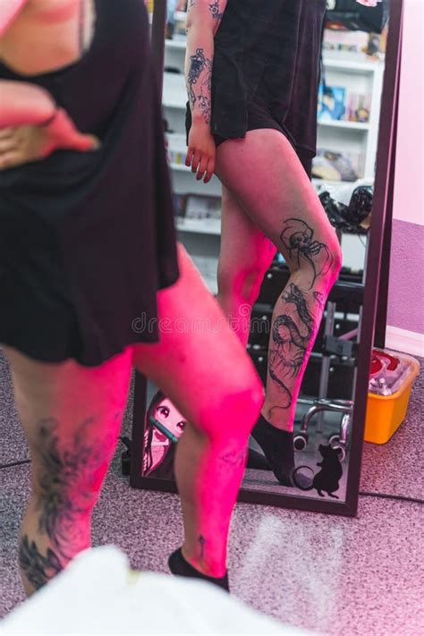Garota Desconhecida Batendo Sua Nova Tatuagem Na Perna No Espelho Foto
