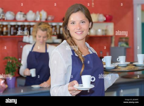Pretty Waitresses Behind The Counter Working At The Coffee Shop Stock