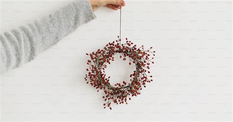 흰색 배경에 꽃집 손에 크리스마스 화환 휴일 강림 붉은 열매 소박한 창조적 인 장식으로 간단한 크리스마스 화환을 들고 여성 손 사진 Unsplash의 제조 대상 이미지