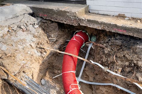 빨간색 골판지 파이프는 전기 케이블 인프라 설치를 위해 만들어진 거리의 지하에 묻혀 있습니다 에너지 공급이 많은 건설 현장 케이블 0명에 대한 스톡 사진 및 기타 이미지
