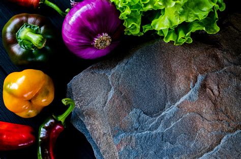 텍스트가 있는 야생 의 여러 가지 색의 돌은 신선한 파란색 양파 노란 고추 칠리 및 양상추 옆에있는 검은 색 테이블에 놓여 있습니다 개념에 대한 스톡 사진 및 기타 이미지