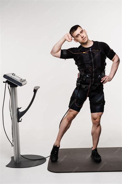 Ems 수트를 입은 근육질의 남성 운동선수는 흰색 배경의 근육을 자극하기 위해 전기 자극을 사용하는 운동 스포츠 훈련을 하고