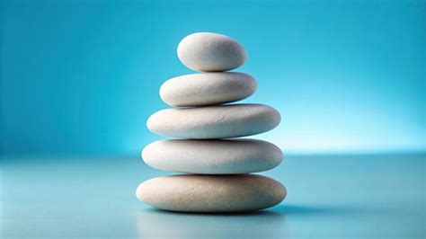 Symmetrical White Sea Pebble Stone Stack On Light Blue Background