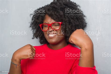 젊은 아프리카계 미국인 플러스 크기 여자 겨울 스웨터 매우 행복 하 고 무기와 우승자 제스처를 하 고 흥분을 입고 회색 그런 지