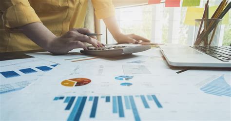 사업가 또는 회계사가 재무 데이터 보고서 회계 문서 및 사무실에서 노트북 컴퓨터를 계산하기 위해 계산기로 작업하는 연필을 들고 있는 클로즈업 비즈니스 개념 사진