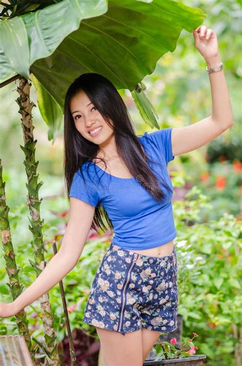 Giovane Ragazza Asiatica Che Sta Sotto La Foglia Fotografia Stock