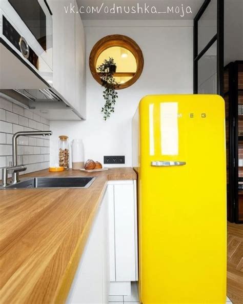 A Yellow Refrigerator Sitting In The Middle Of A Kitchen