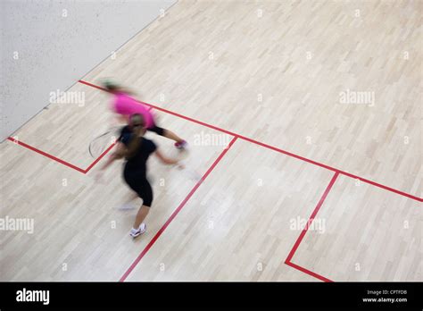 Two Female Squash Players In Fast Action On A Squash Court Motion Blurred Image Color Toned