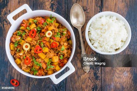 고전적인 쿠바 접시 Picadillo 갈은 쇠고기와 토마토 건포도와 흰색 캐 서 롤 및 나무 시골풍 테이블에 삶은 쌀에 올리브의