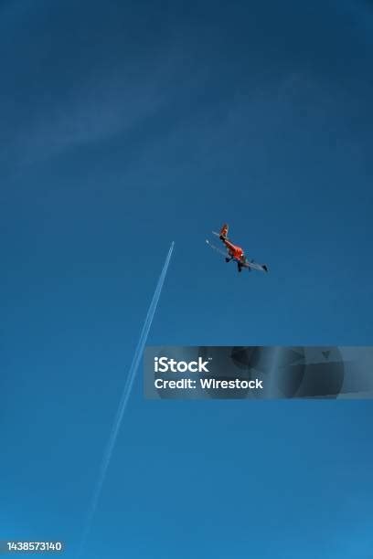 낮 동안 하얀 줄무늬 흔적이있는 푸른 하늘을 날아 다니는 빨간 비행기 0명에 대한 스톡 사진 및 기타 이미지 0명 날기 낮 Istock