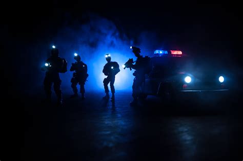 반폭동 경찰은 준비 신호를 제공합니다 정부 권력 개념 경찰은 행동중입니다 어두운 배경에 조명이 있는 연기 파란색 빨간색 깜박이는 사이렌 독재 권력 경찰관에 대한 스톡 사진