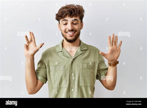 Junger arabischer Arzt der über einem isolierten Hintergrund steht zeigt und zeigt mit den