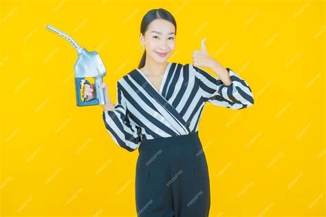 노란색에 세로 아름 다운 젊은 아시아 여자 Feul 가스 펌프 무료 사진