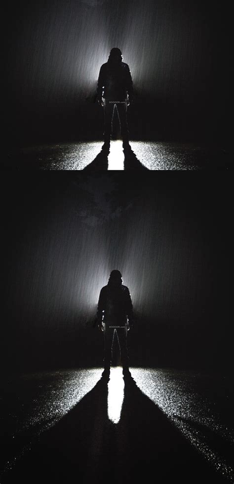 雨天素材设计一个人站在户外淋着雨一束光打在他的身上形成一道阴影