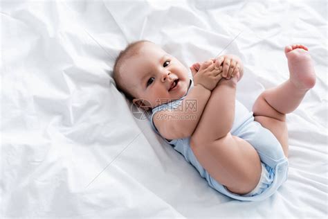 婴儿男孩在躺床上时触高清图片下载 正版图片503069056 摄图网