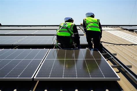 태양 전지 농장 발전소 옥상에서 태양 전지판 시스템을 점검하고 운영하는 노트북을 사용하는 엔지니어 및 기술자 전기 및 전력을위한