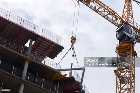 타워 마스트 크레인입니다 강철 로프에 강철 체인에 후크와 블록을 게양 거대한 강철 빔을 들어 올립니다 적재건설 건축 현장에서 건축 자재의 하역 강철에 대한 스톡 사진 및