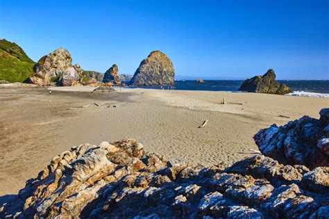 Rugged Rock Formations And Sandy Beach Under Clear Sky At Harris Beach