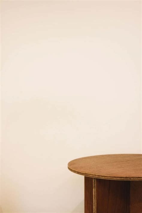 Download A Round Wooden Table Standing On A Sunlit Exterior Background
