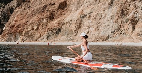 여자는 요가를 한다 패들 섭 서핑보드에서 요가 필라테스를 연습하는 행복한 스포티한 여성 바닷물에서 운동을 하는 여성 스트레칭