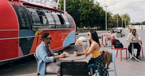 패스트 푸드와 음료를 먹으면서 야외 카페에서 테이블로 상호 작용하는 행복한 젊은 커플 사진 Unsplash의 사람 이미지