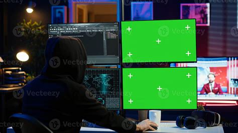 Hooded Man Writing Lines Of Code On Green Screen Pc From Apartment