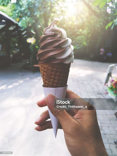 아이스크림 바닐라와 초콜릿 와플 콘 종이 랩 남자 손 맛 있는 디저트 아침 휴가에 흐림 배경과 태양 빛과 함께 맛 있는 야외 자연 공원 아이스크림에 대한 스톡 사진 및 기타