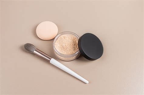 베이지 배경에 자연스러운 톤의 드라이 파우더 둥근 스폰지 아름다운 메이크업 브러시가 있는 오픈 화장품 항아리 장식 화장품의 개념 0명에 대한 스톡 사진 및 기타 이미지