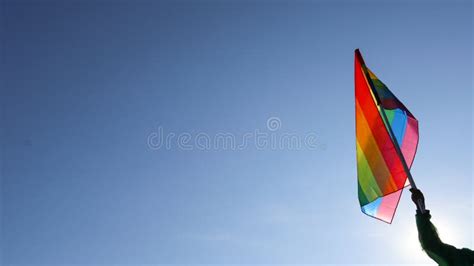 Look Up View Of Rainbow Lgbt Flag Waving In The Blue Sky Background