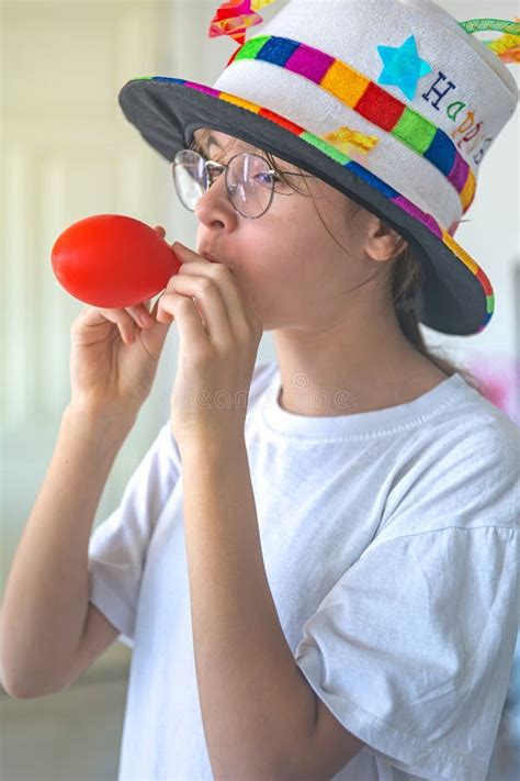A Festive Girl Inflates A Balloon On Her Birthday Birthday Concept