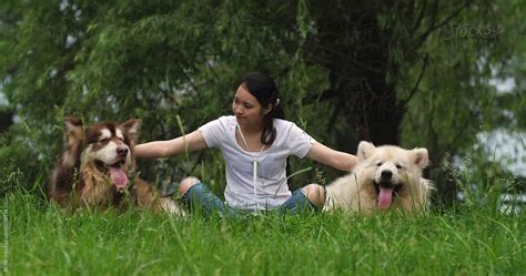 Young Asian Woman With Her Big Dog Outdoor In The Park By Stocksy
