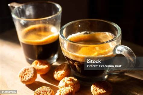 작은 비스킷이 있는 나무 표면에 이탈리아 커피 에스프레소의 투명한 컵 2개 아침에 고 대비 사진 배경이 흐려졌습니다 수제 아침 식사 부부 배경 화면 그림 열 개념에 대한