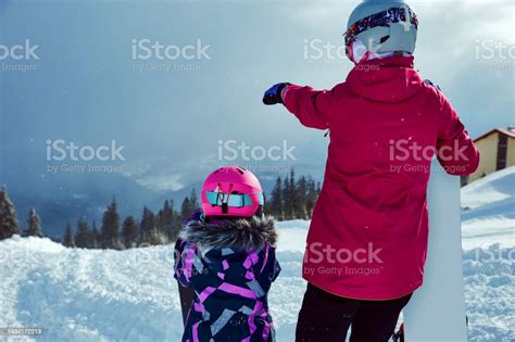 산의 풍경을 함께 보는 스노우 보드가있는 어머니와 딸의 뒷모습 또는 화창한 겨울날에 스키 리조트를 타는 새로운 방법 여행 휴가 풍경 산 배경 2명에 대한 스톡 사진 및 기타