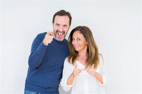 아름 다운 중간 나이 부부는 행복 하 고 재미 있는 얼굴로 카메라에 손가락을 가리키는 고립 된 배경 위에 사랑 좋은 에너지와 느낌 명랑한에 대한 스톡 사진 및 기타 이미지