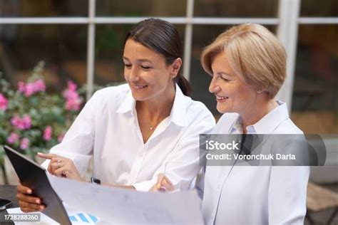 사무실 테라스에 앉아 디지털 태블릿을 바라보는 프로젝트를 진행하는 두 명의 비즈니스 동료 2명에 대한 스톡 사진 및 기타 이미지 2명 45 49세 55 59세