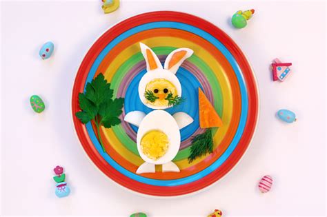 아이들을위한 부활절 아침 식사 아이디어 여러 가지 빛깔의 접시에 삶은 계란으로 만든 토끼 토끼 흰색 배경 상단 보기 아이들을위한 창조적 인 재미있는 음식 0명에 대한 스톡