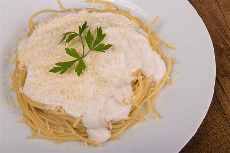 간 치즈와 파슬리 잎을 곁들인 베샤멜 소스를 곁들인 파스타는 화이트 플레이트에 얹어 드실 수 있습니다 왼쪽에 음식과 클로즈업 사진 강판에 갈기에 대한 스톡 사진 및 기타