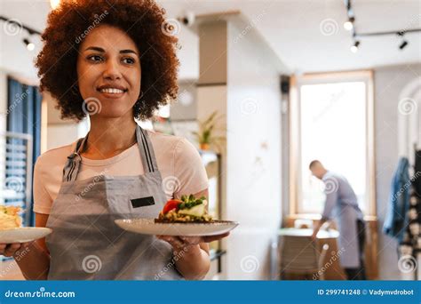 Smiling Waitress Carrying Plates With Meal While Working In Cafe Stock