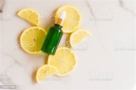 화장품 레몬 오일 또는 에센셜 오일은 레몬 슬라이스와 대리석 테이블의 배경에 녹색 유리 파이펫병 가꿔주기에 대한 스톡 사진 및 기타 이미지 Istock