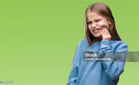 치 통 이나 치아에 치과 질병 때문에 고통 스러운 표정으로 손으로 입 만지고 격리 된 배경 위에 겨울 스웨터를 입고 젊은 아름 다운 소녀 치과 개념입니다 가을에 대한 스톡