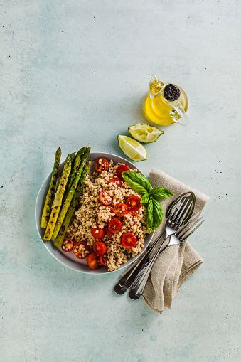 샐러드 글루텐 밀 구운 아스파라거스와 체리 토마토 Tahini 참 깨 파스타 소스와 라임 주스와 테이블에 접시에 체 강 질병을