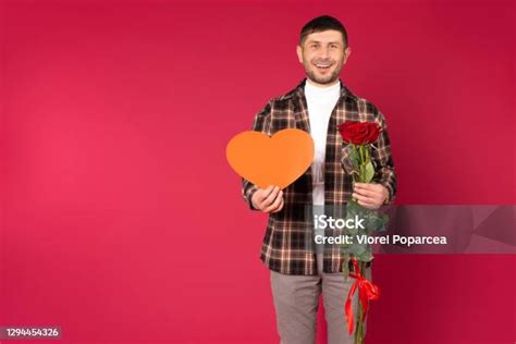 세인트 발렌타인 데이에 장미 꽃다발과 붉은 마음을 가진 잘 생긴 젊은 남자 빨간색 배경과 빈 측면 공간입니다 2월에 대한 스톡 사진 및 기타 이미지 Istock