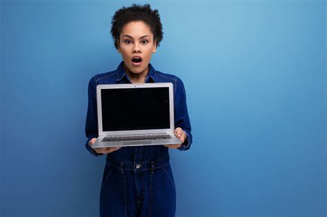 파란색 데님 정장을 입은 검은 피부와 검은 곱슬 머리를 가진 젊은 성공한 여성이 노트북 화면에서 프로젝트를 시연합니다 20 24세에 대한 스톡 사진 및 기타 이미지 Istock