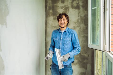 마스터는 벽에 화이트 퍼 티를 적용 하 고 낮에 집 리 모델링의 방에 퍼 티 나이프에 의해 번짐 Diy에 대한 스톡 사진 및 기타 이미지 Istock