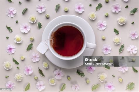 베이지 색 배경에 꽃 무늬가 있는 차와 화이트 세라믹 컵 꽃 차 개념입니다 티백 맨 위 보기 국화에 대한 스톡 사진 및 기타